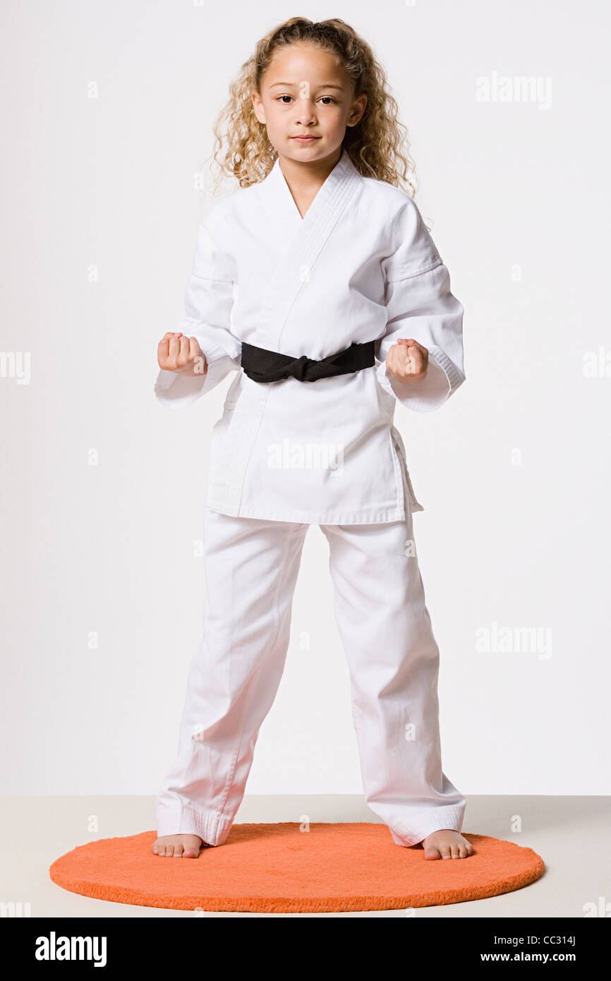 Studio portrait of smiling girl (8-9) wearing gi Stock Photo - Alamy