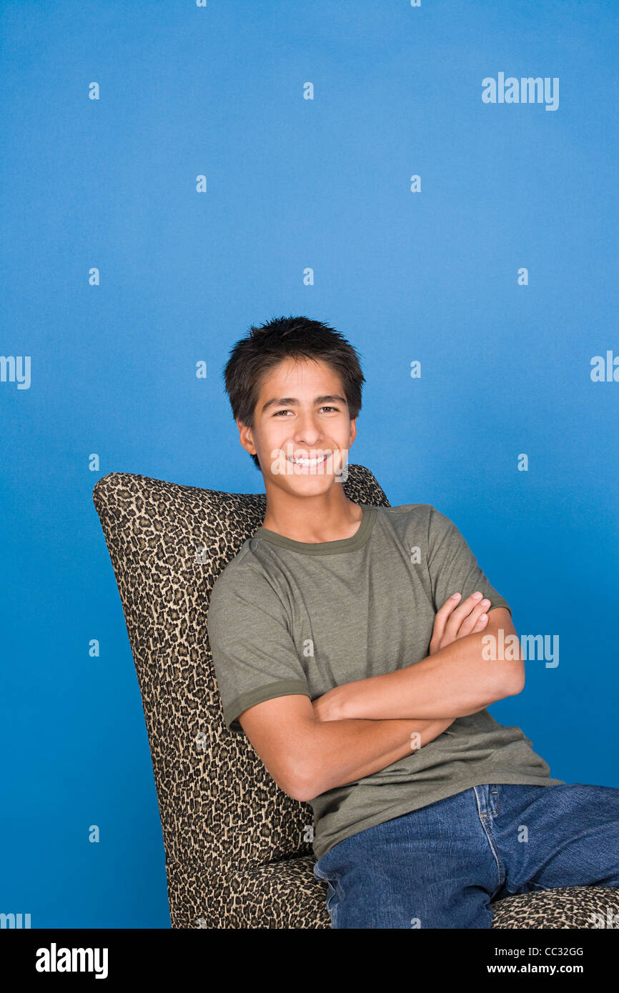Portrait of teenage boy (16-17) sitting in chair Stock Photo - Alamy