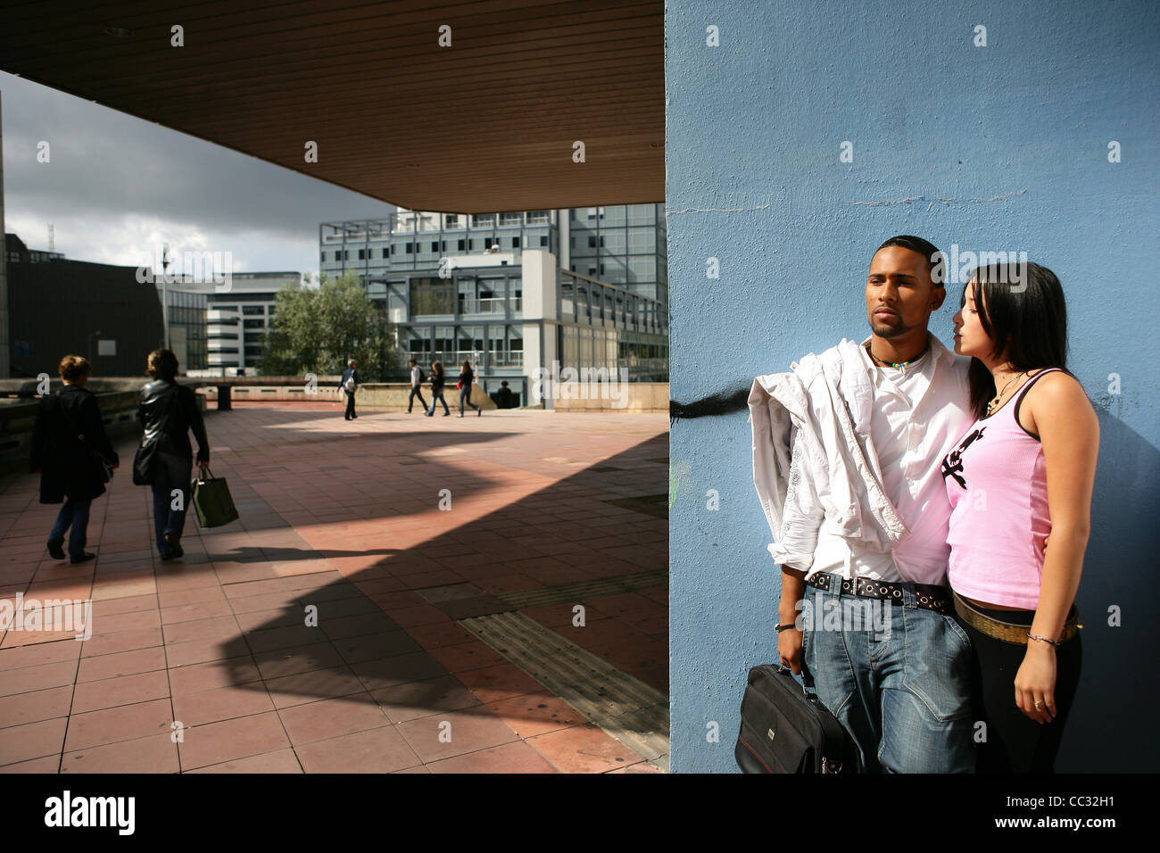Young couple stood by large city building Stock Photo - Alamy