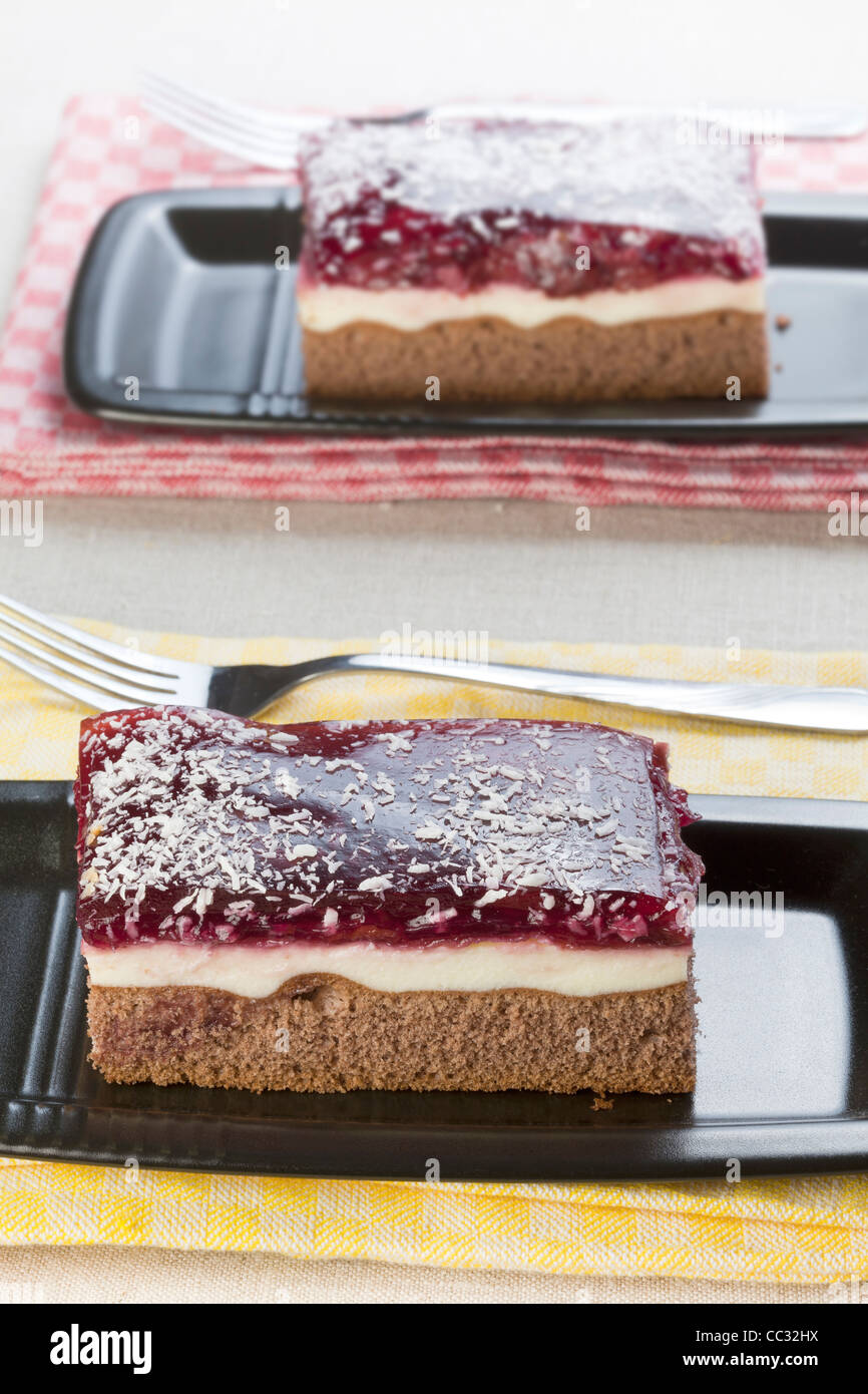 Two slices of cake, chocolate with cream and fruit topping Stock Photo ...