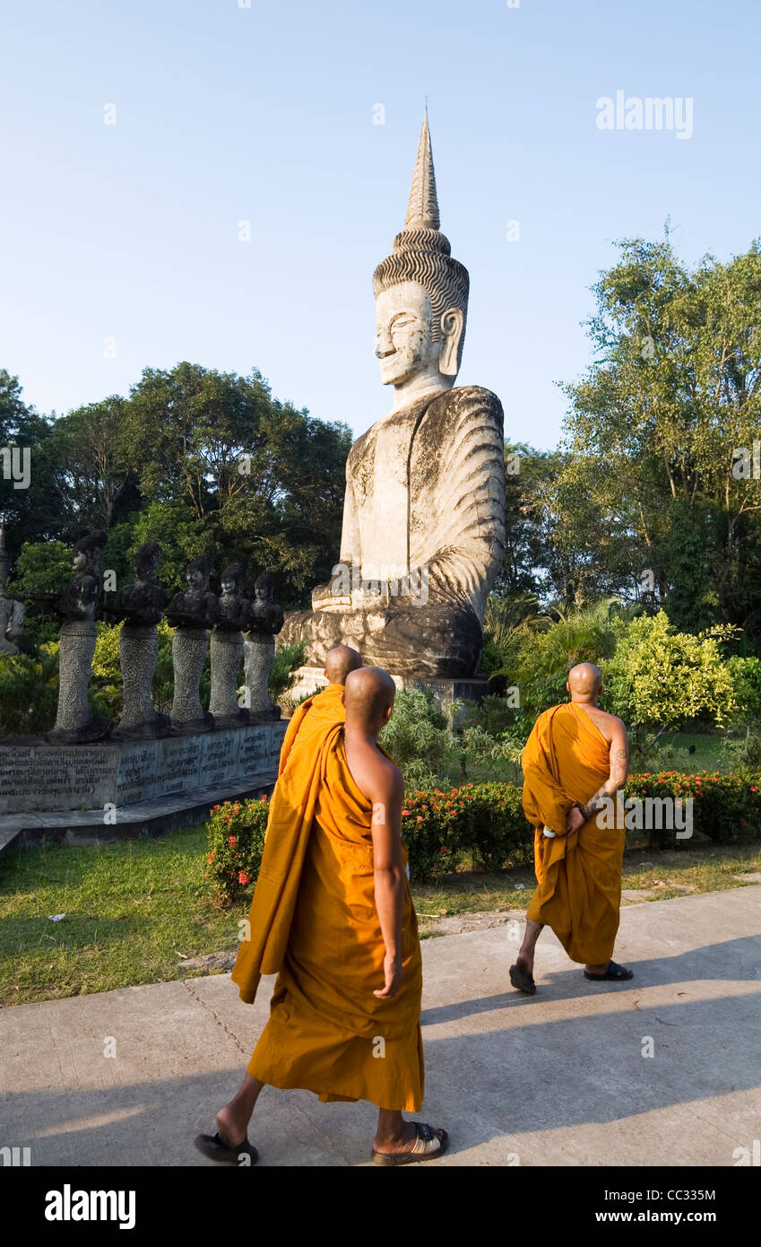 Monks walk amongst the giant sculptures of the Sala Kaew Ku Sculpture ...