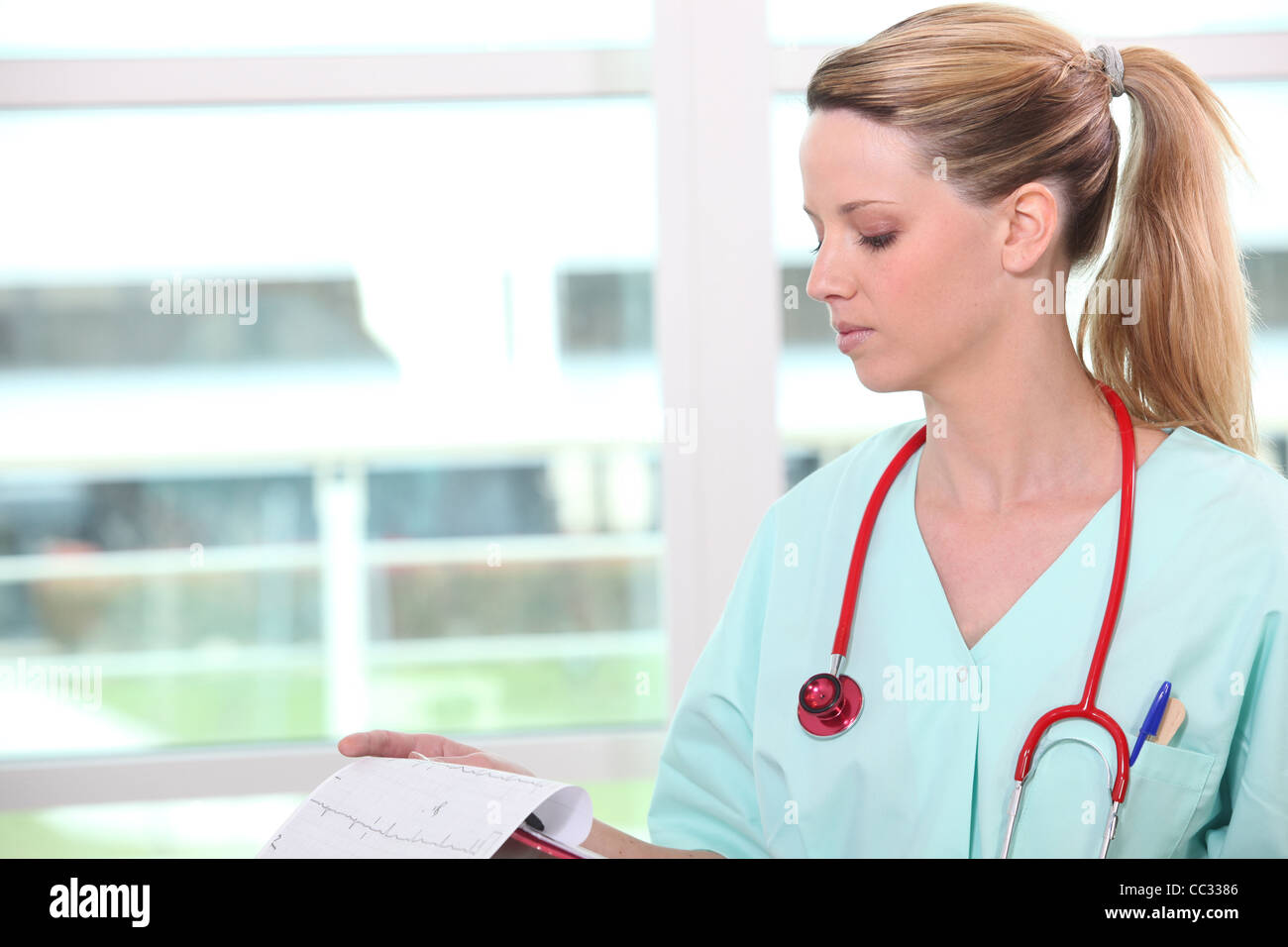a female nurse reading a paper Stock Photo - Alamy