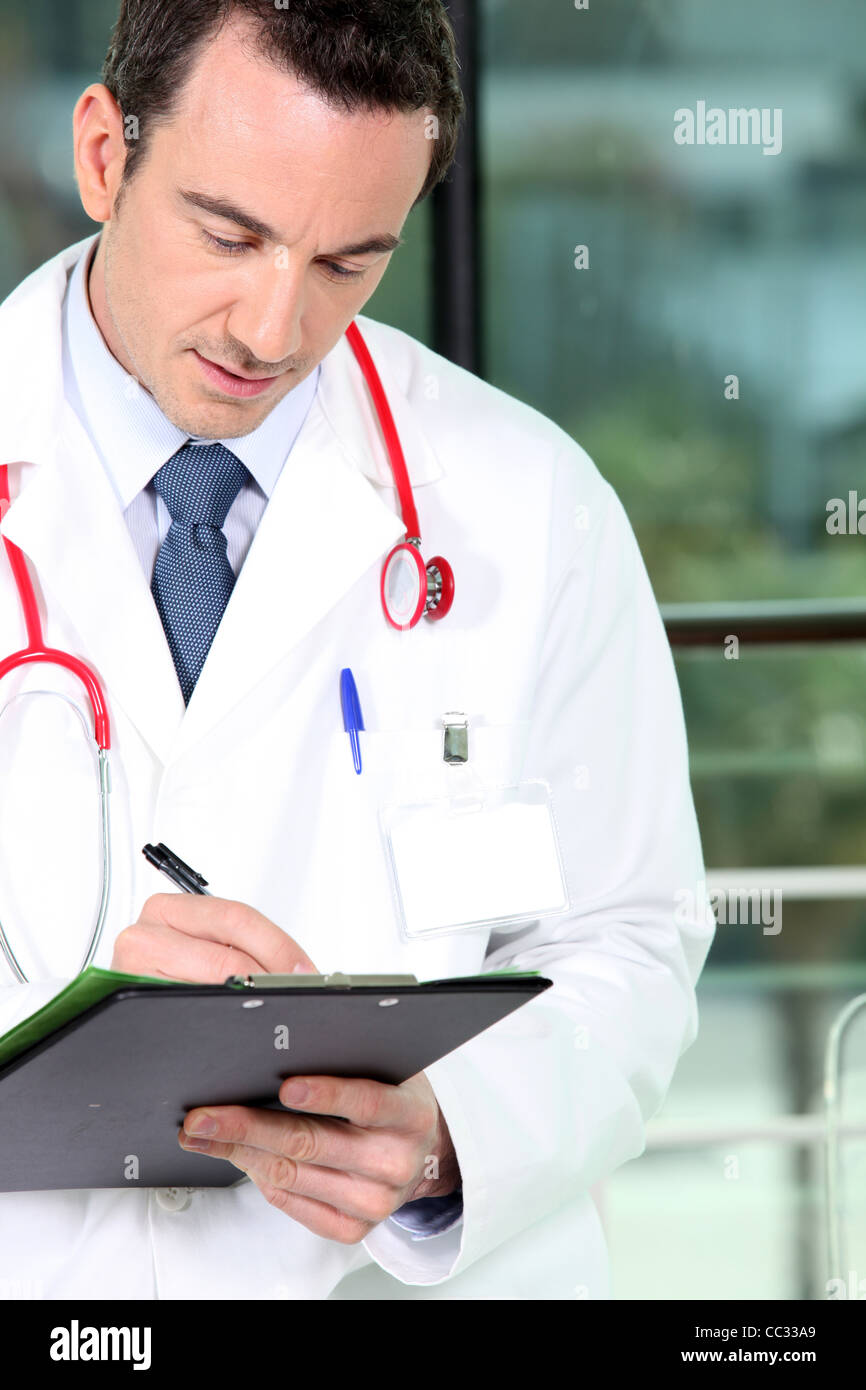 Doctor writing on a clipboard Stock Photo - Alamy