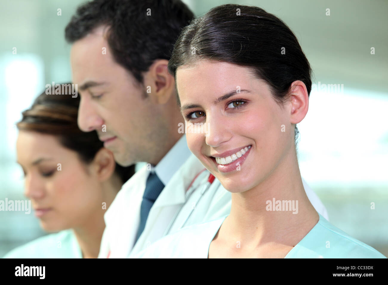 Smiling hospital nurse standing with colleagues Stock Photo - Alamy