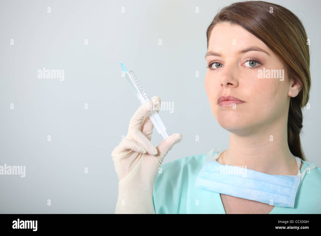 Brunette nurse holding syringe Stock Photo - Alamy