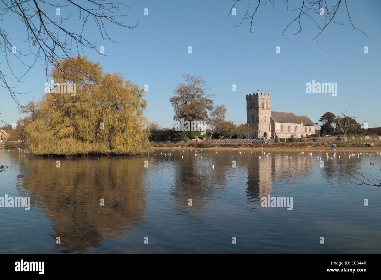 Village pond with St Laurence church behind in the pretty village of ...