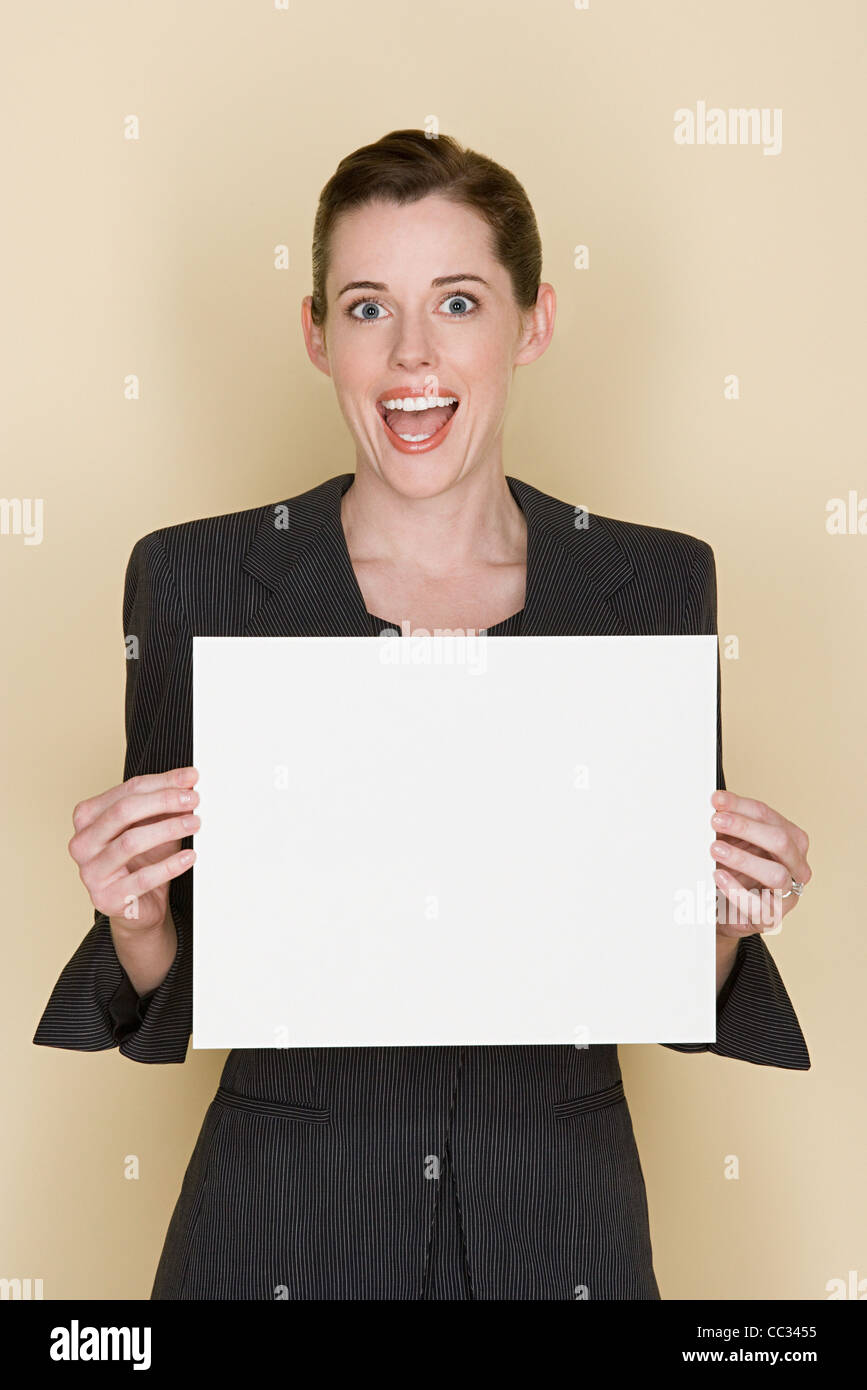 Portrait of happy mid-adult woman holding blank sheet of paper Stock ...