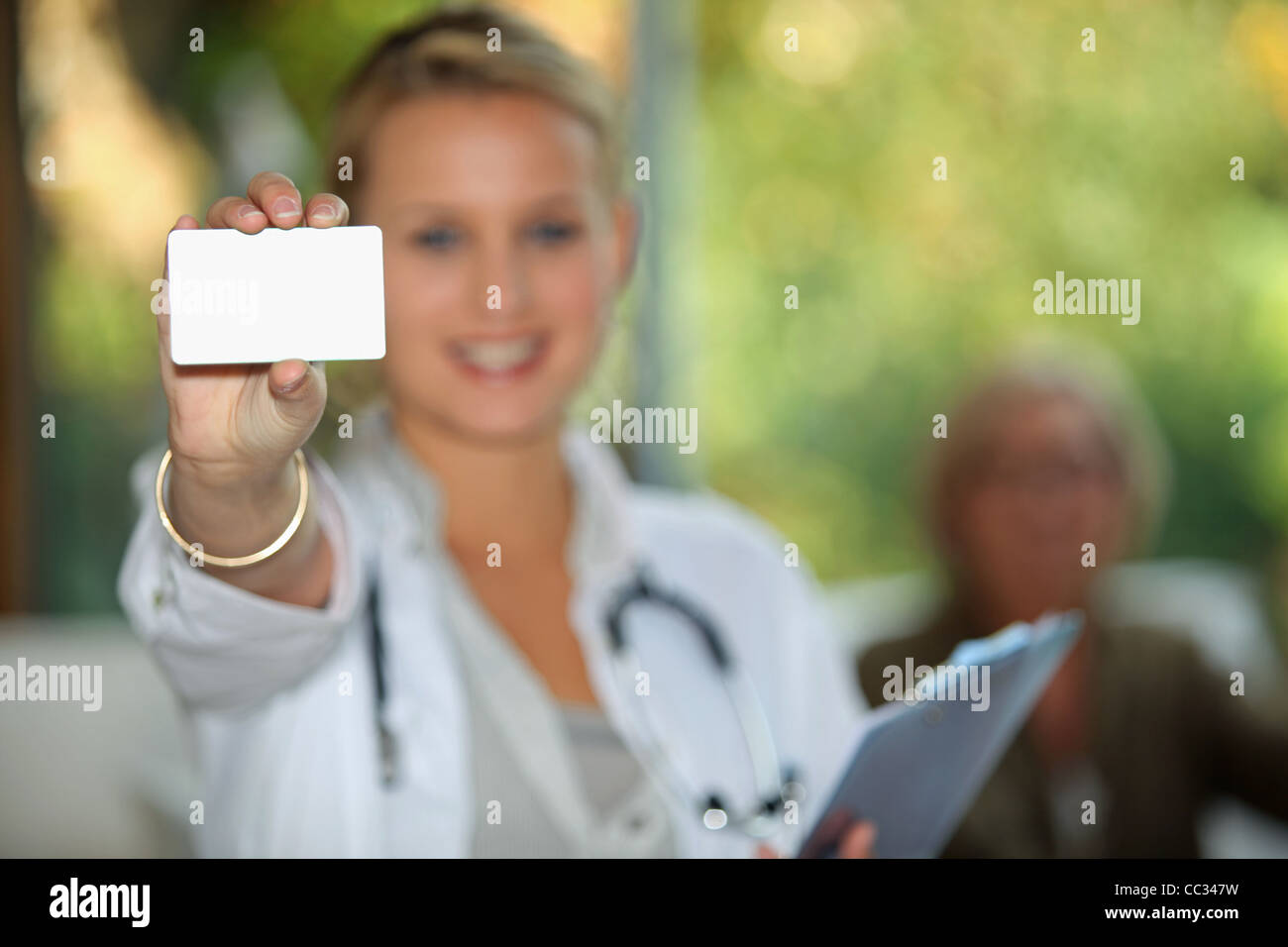 Doctor showing business card Stock Photo - Alamy