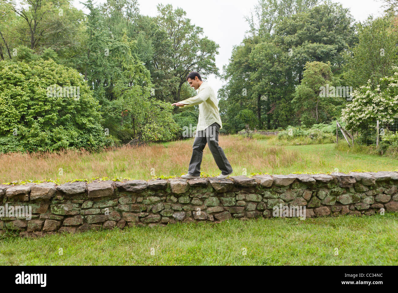 USA, New Jersey, Man walking on stone wall on field Stock Photo - Alamy