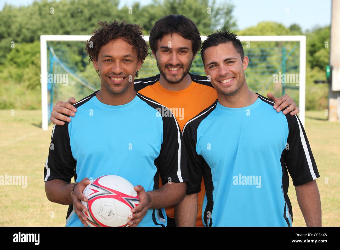 Three young footballers in front of goal Stock Photo - Alamy