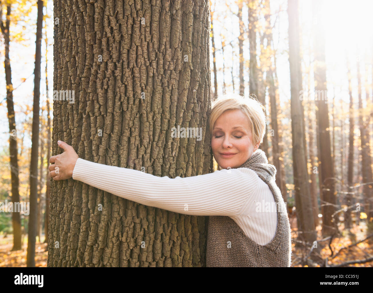 Mature woman hugging tree in forest hi-res stock photography and images ...