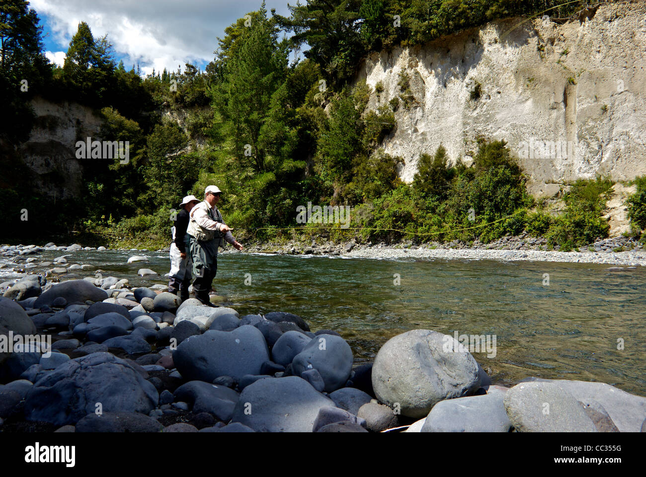 Fly fisherman casting flyline deep pool rainbow trout fishing Tongariro ...