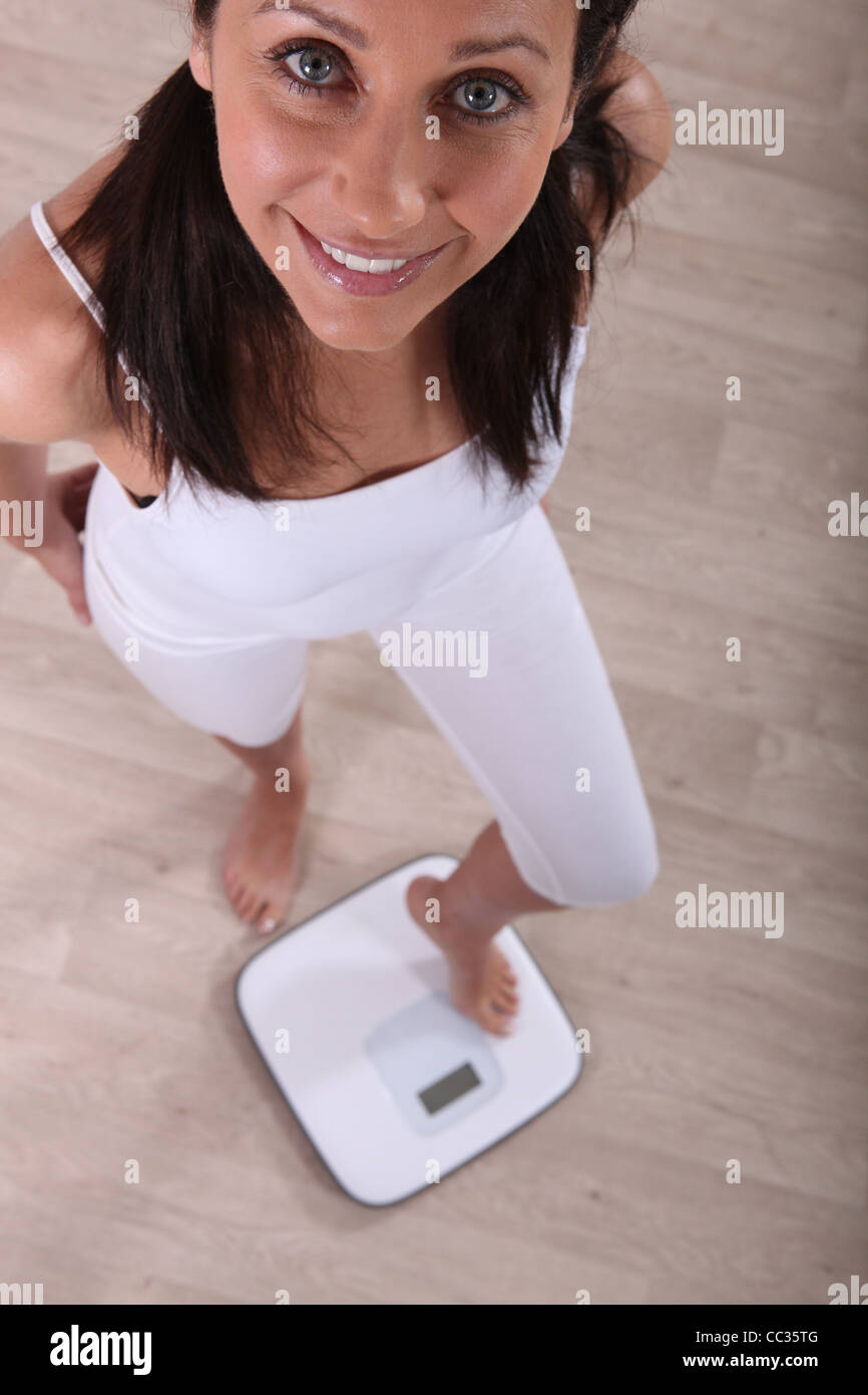 Woman standing on Scales Stock Photo - Alamy
