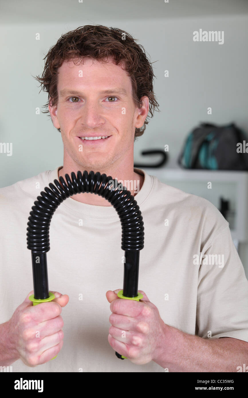 Man squeezing an expander bar Stock Photo - Alamy