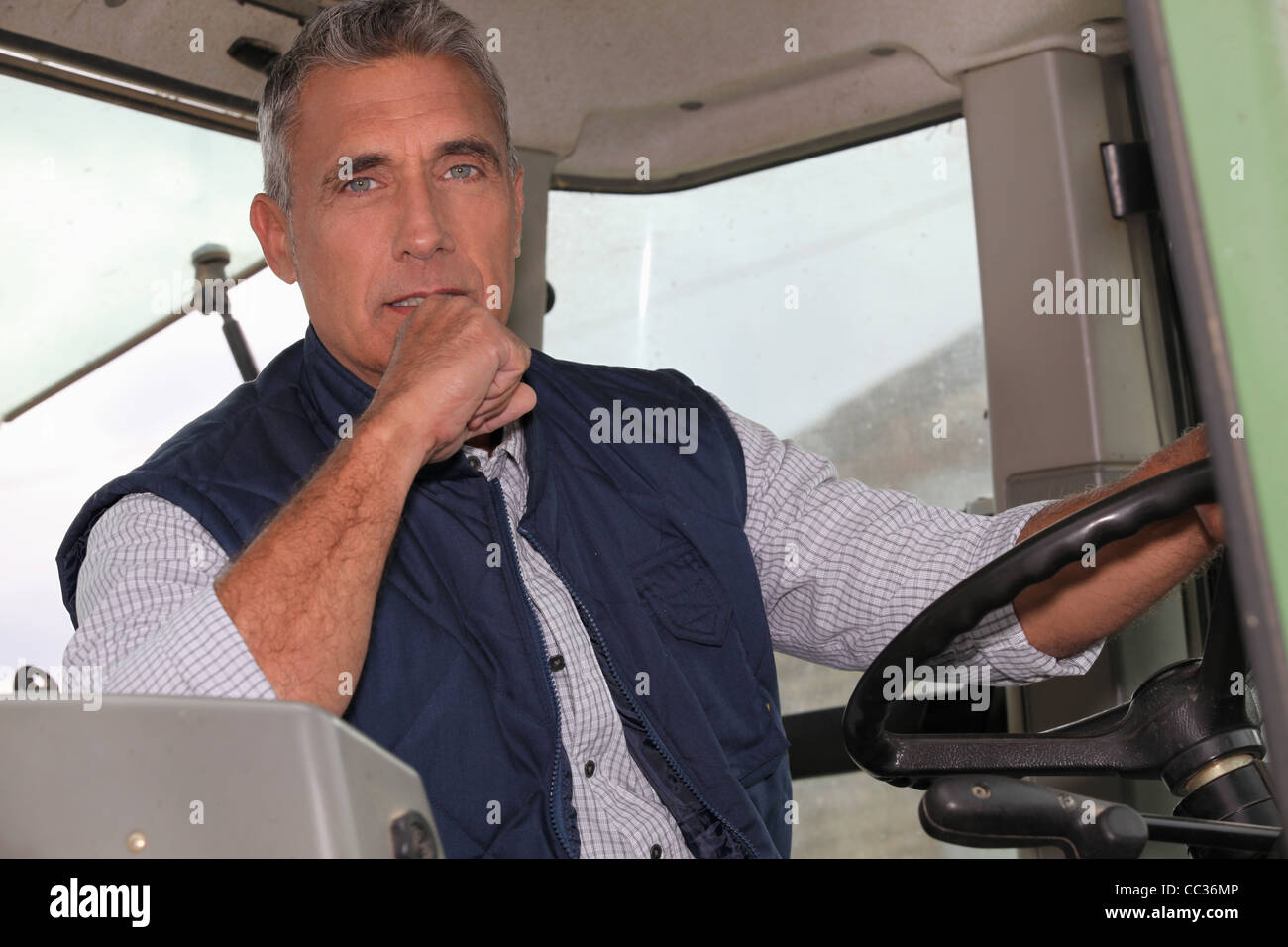 a farmer in a tractor cabin is driving Stock Photo - Alamy