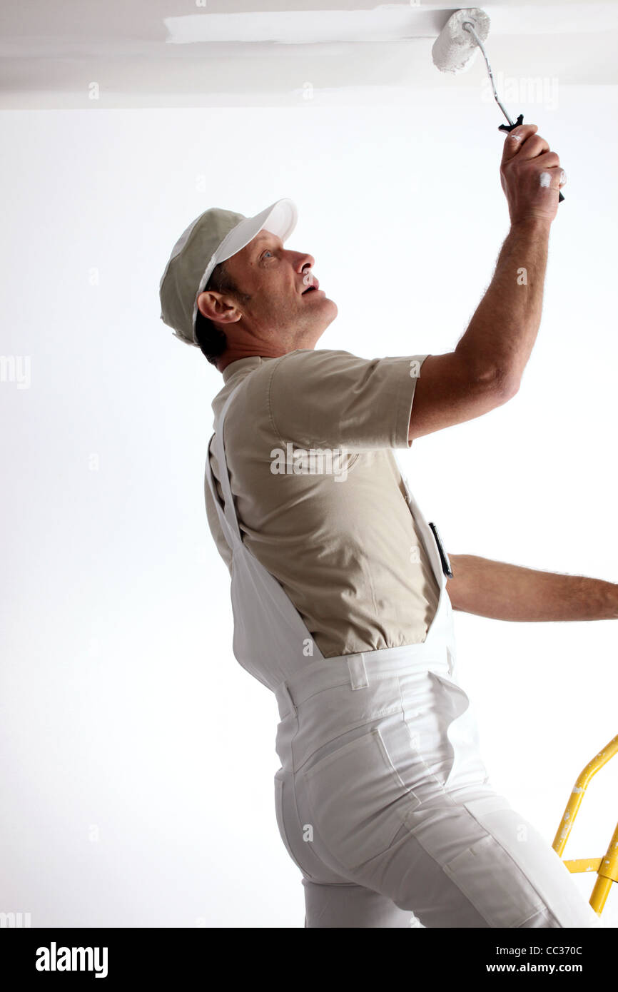 Man repainting ceiling with roller Stock Photo - Alamy