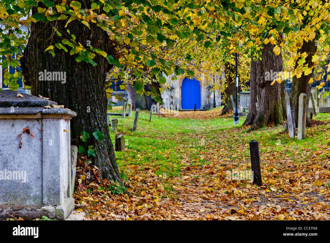 Churchyard and blue church door in Autumn or Fall in Suffolk, England ...