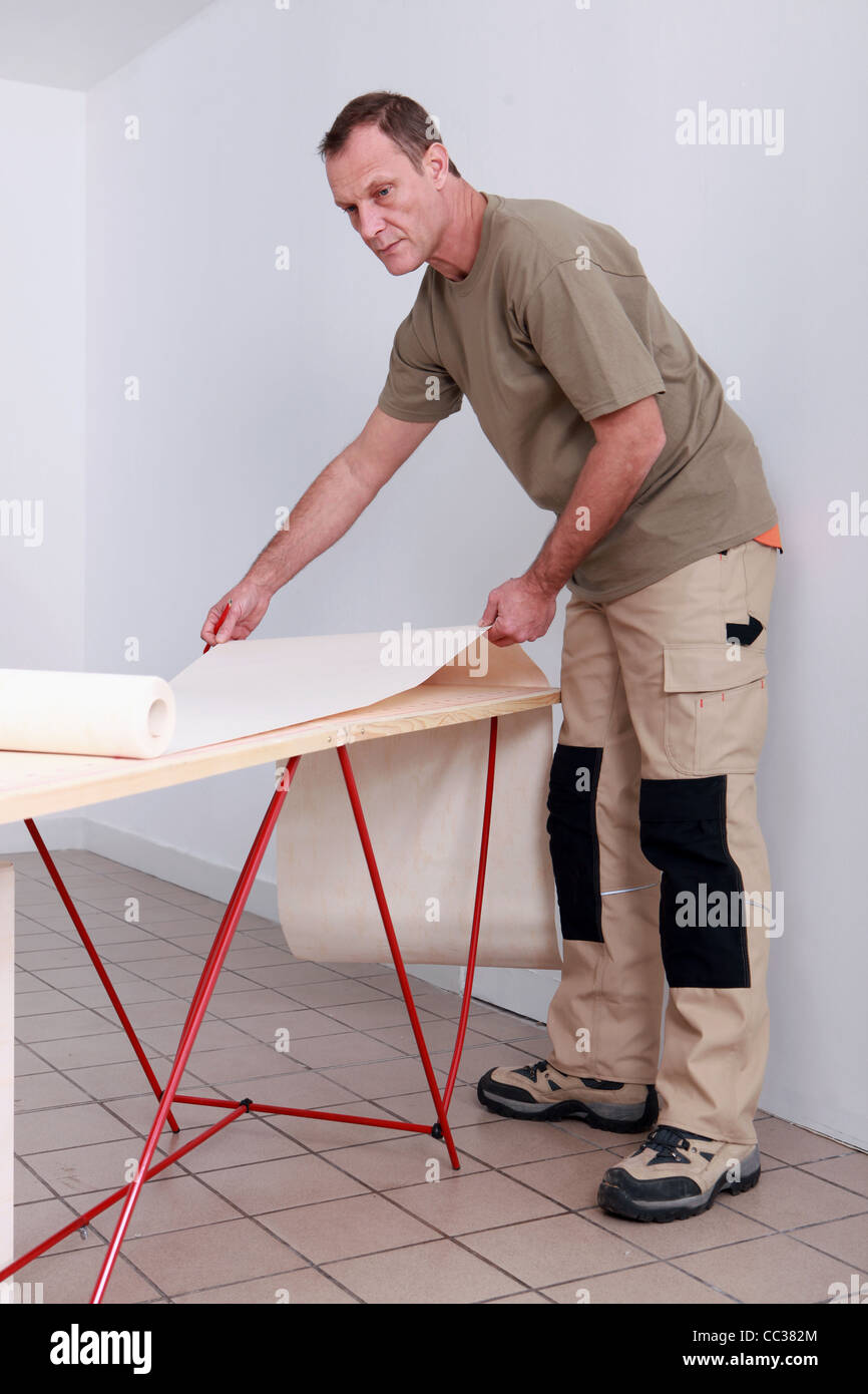 Man hanging wallpaper Stock Photo - Alamy