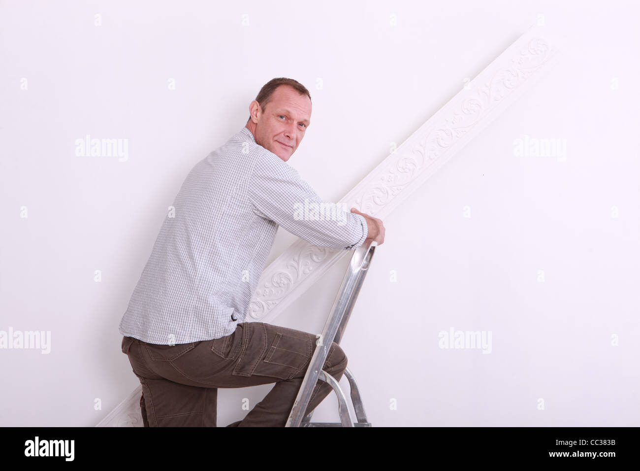 Man with step-ladder holding roll of wallpaper Stock Photo - Alamy