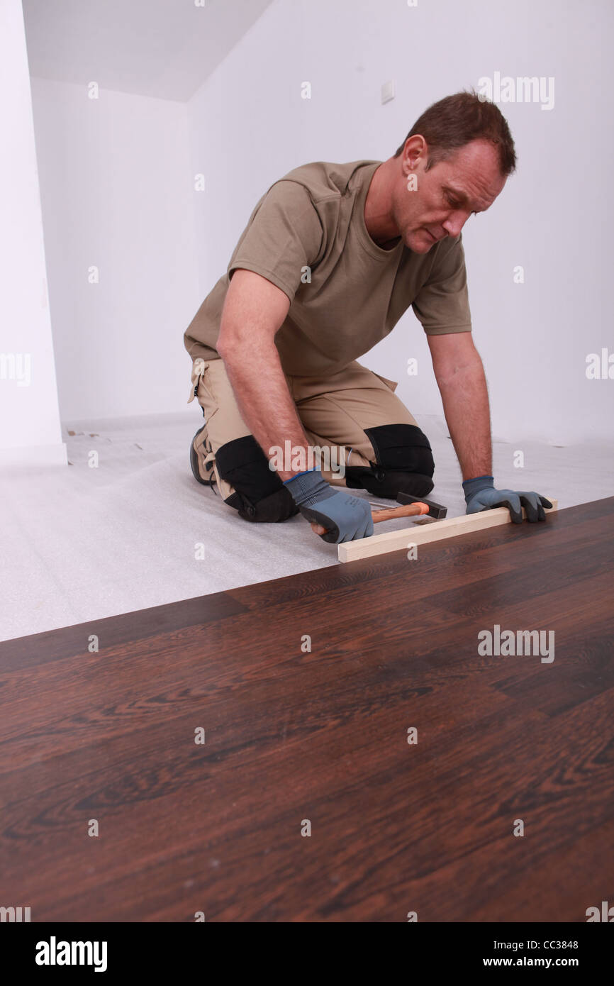 Man laying a wooden floor Stock Photo - Alamy