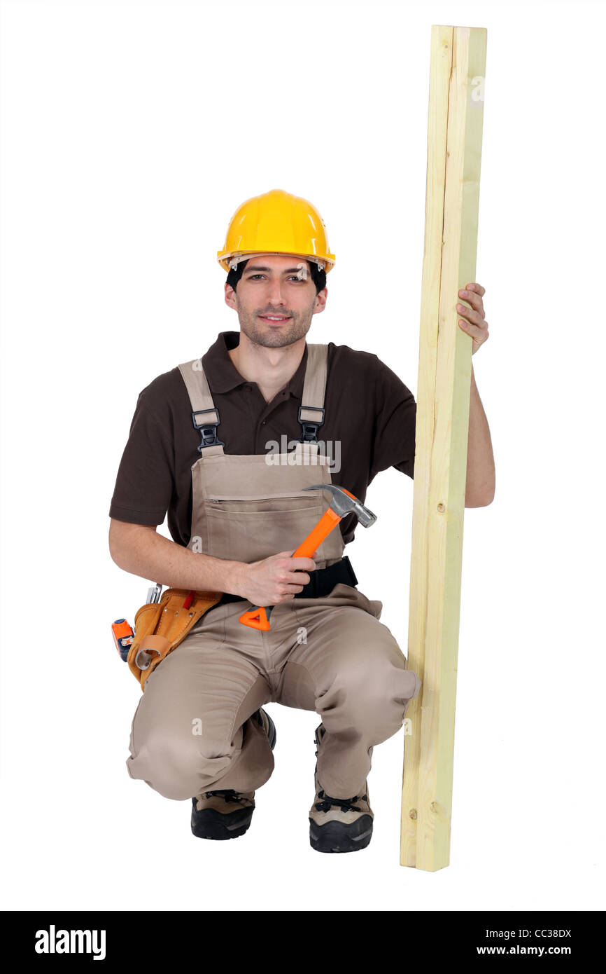 Carpenter with plank of wood and hammer Stock Photo - Alamy