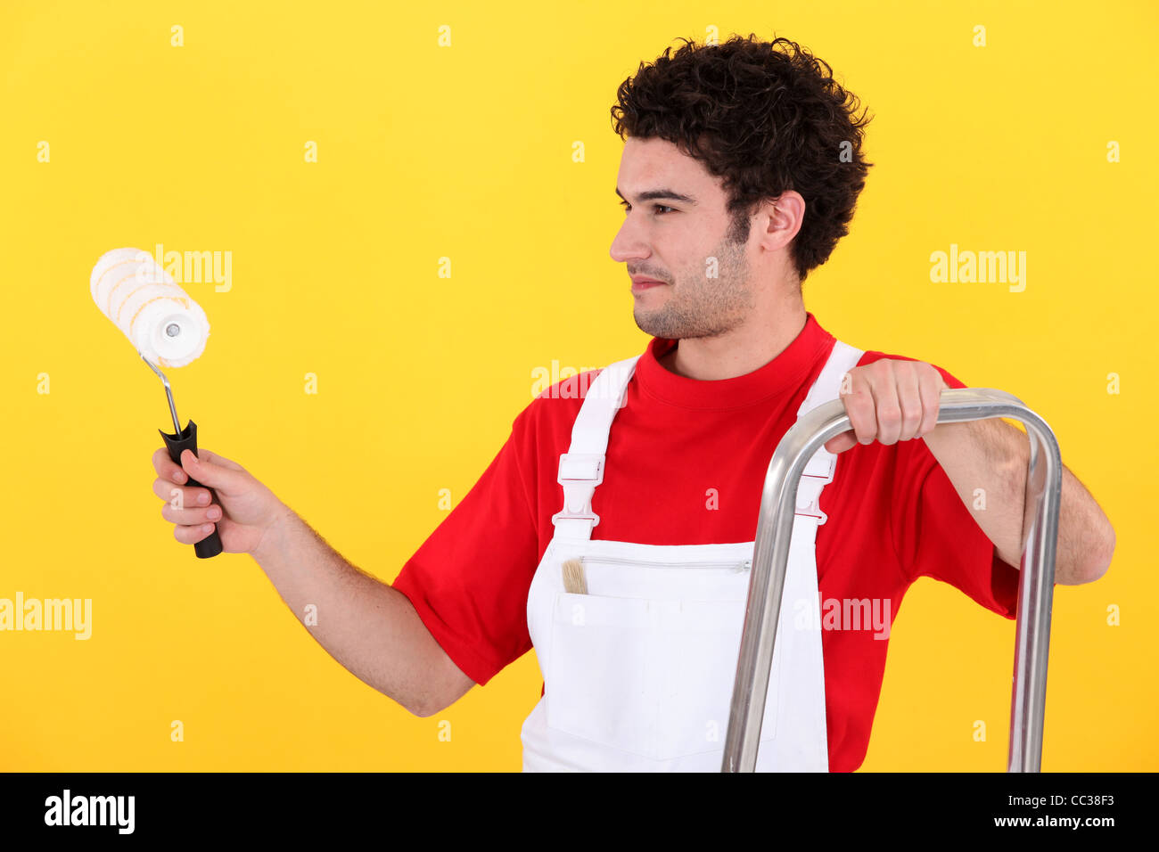 Man with step-ladder using paint-roller Stock Photo - Alamy
