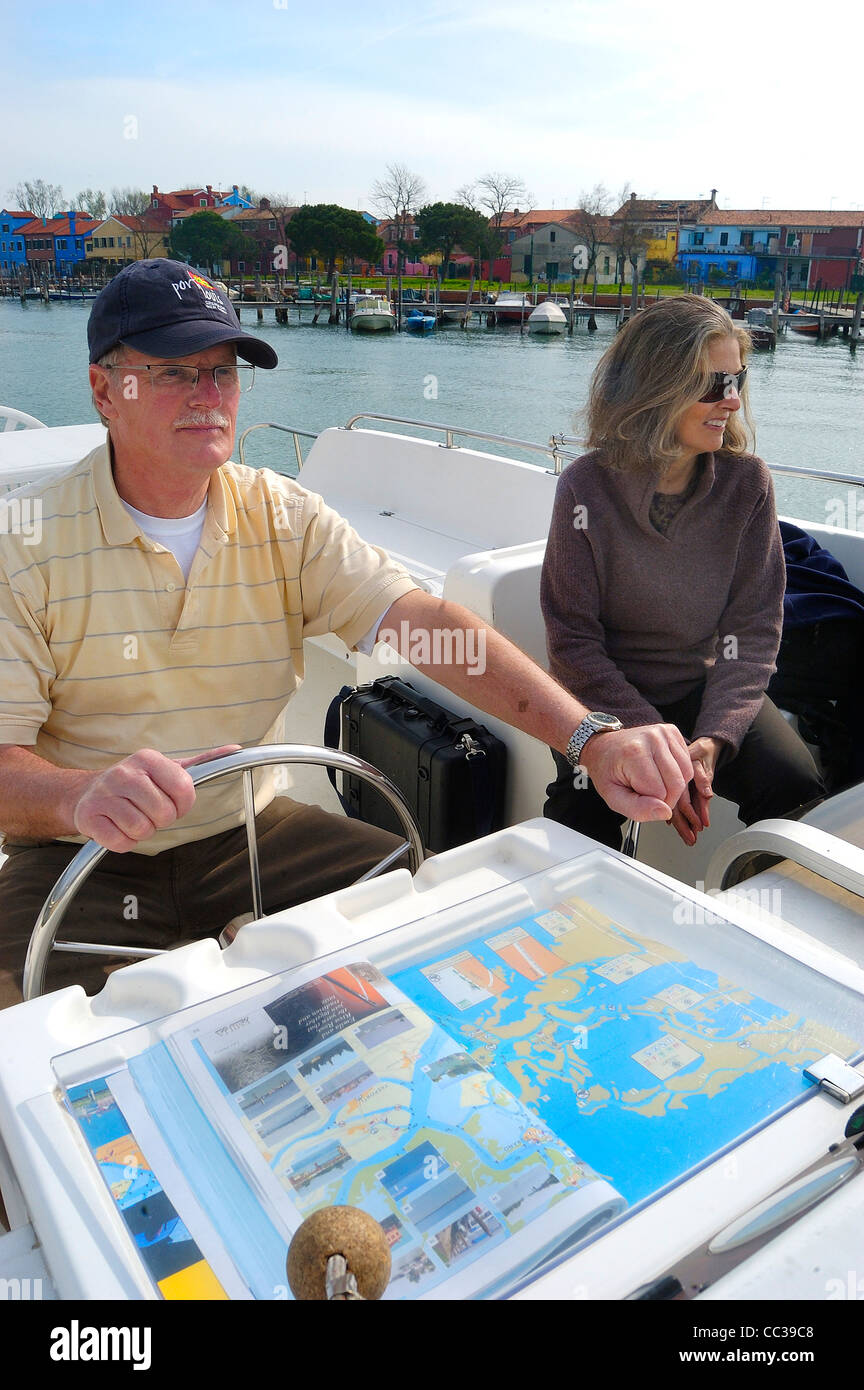 Skipper and crew in cockpit driving a 40 ft charter motor boat past the ...