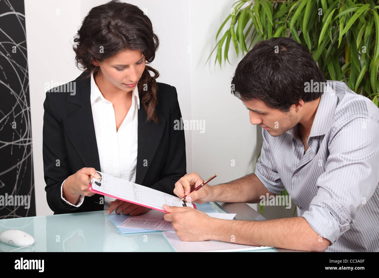 Young man signing a document Stock Photo - Alamy