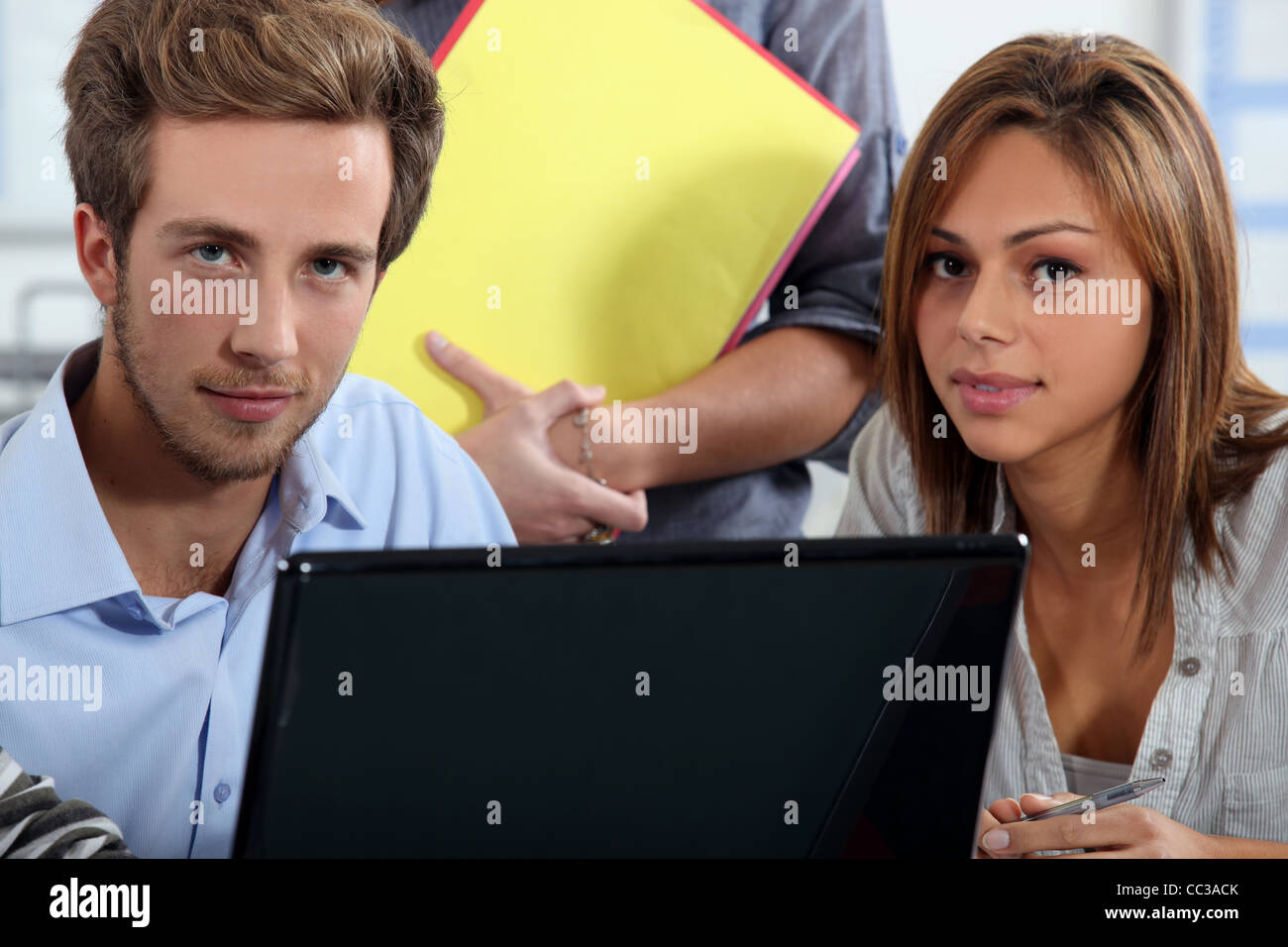 Interns sitting at a desk with computer Stock Photo - Alamy