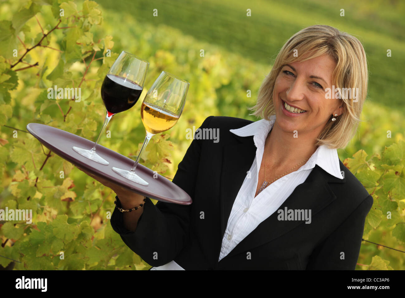 Waitress with red and white wine in a vineyard Stock Photo - Alamy