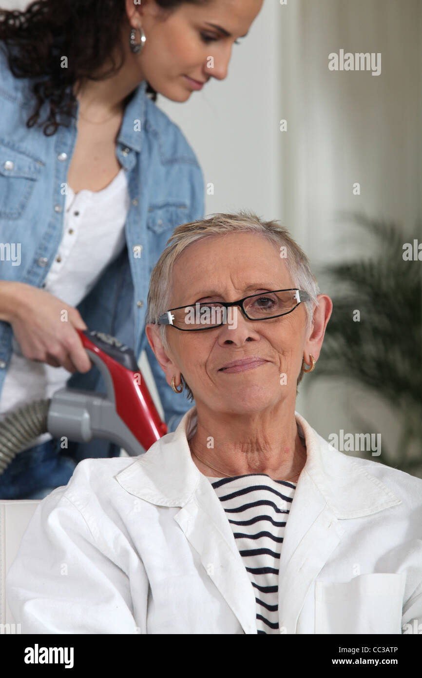 Young woman helping an older lady with the housework Stock Photo - Alamy