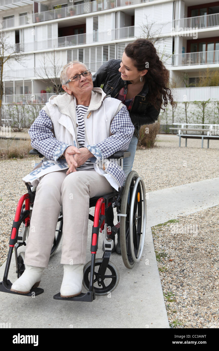 Young woman pushing an elderly woman in a wheelchair Stock Photo - Alamy