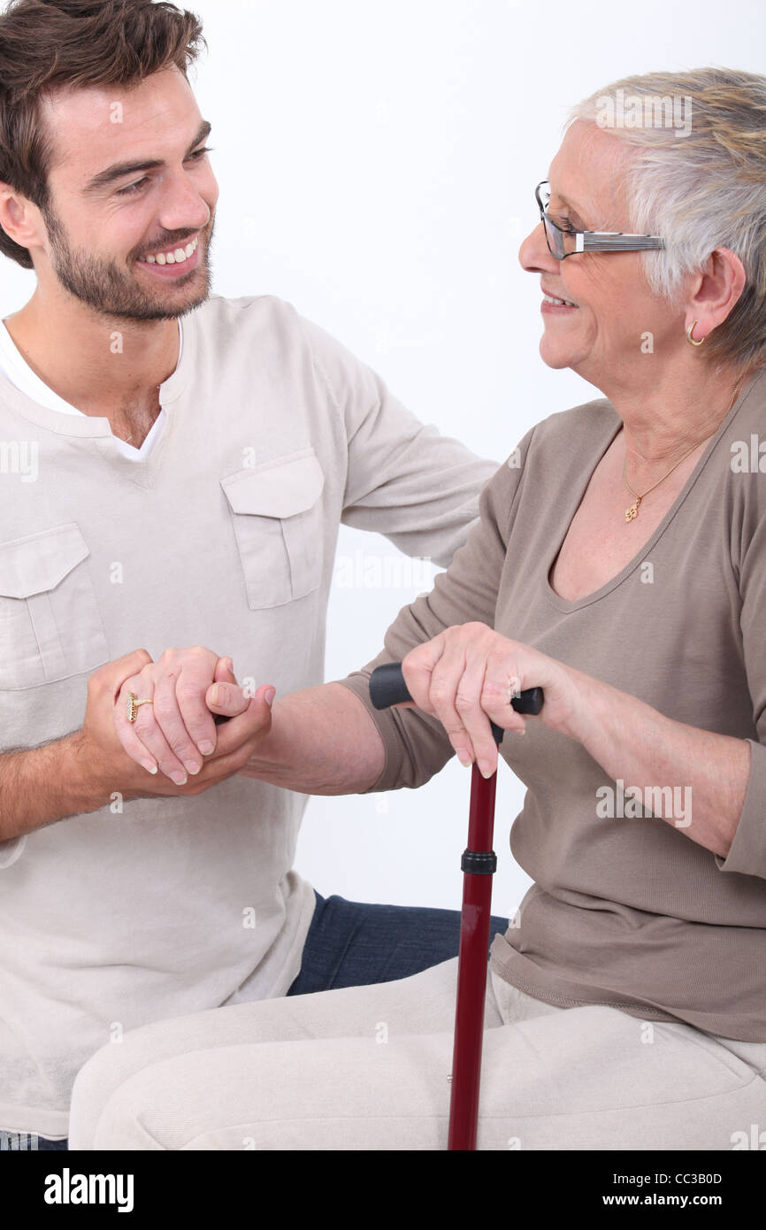 Young man helping senior woman Stock Photo - Alamy