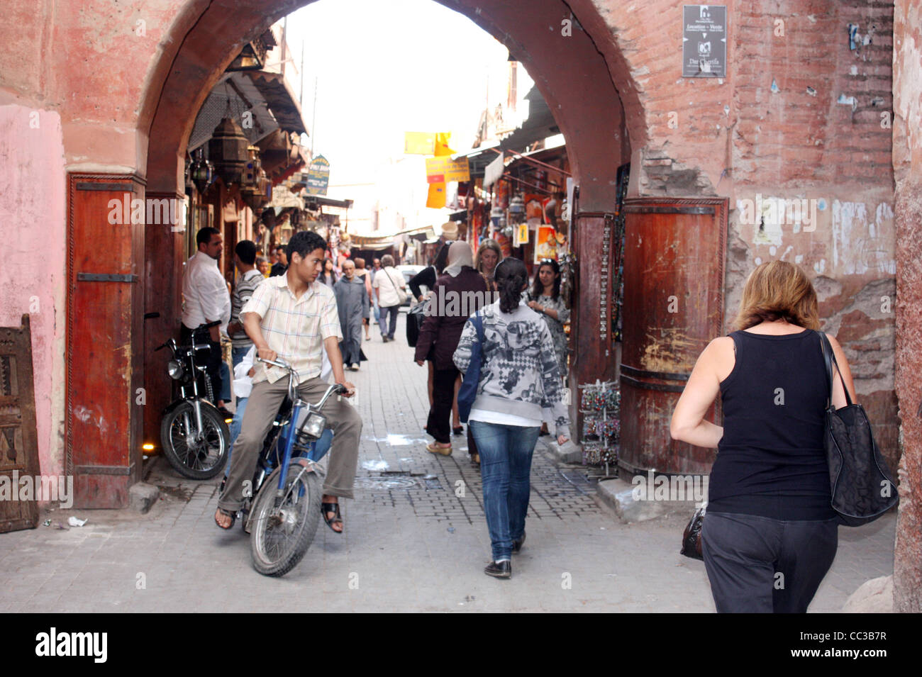 Marrakech alley way in the Medina with pedestrians and cyclists Stock ...
