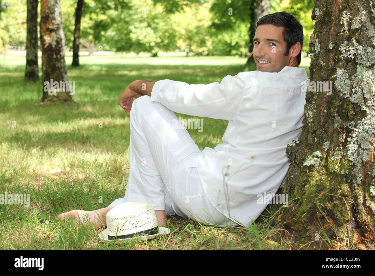 Man leaning against tree Stock Photo - Alamy