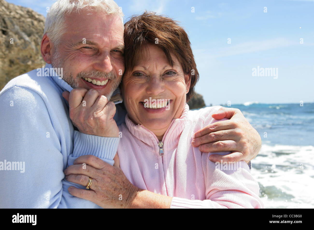 Mature couple hugging by the oceanside Stock Photo - Alamy