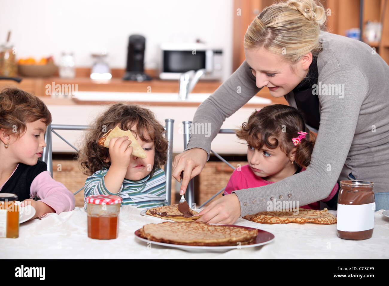 Mother preparing breakfast for kids Stock Photo - Alamy