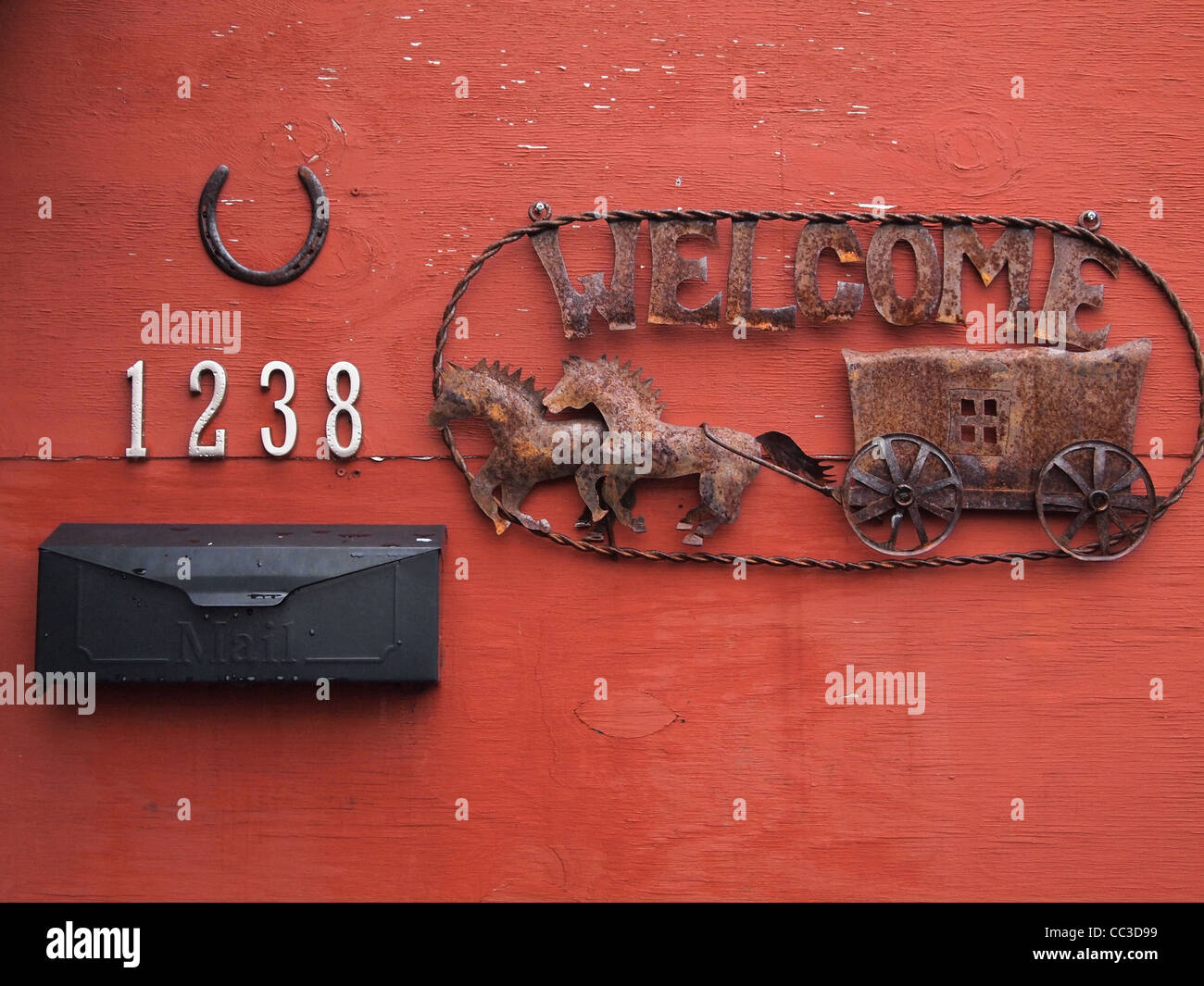 Metal welcome sign with horse drawn covered wagon and a horseshoe at ...