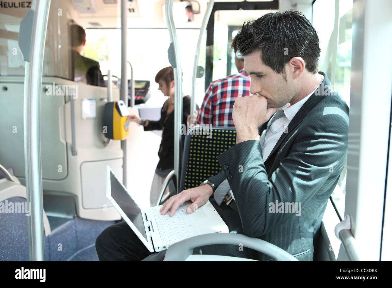 Man using laptop computer on a tram Stock Photo - Alamy