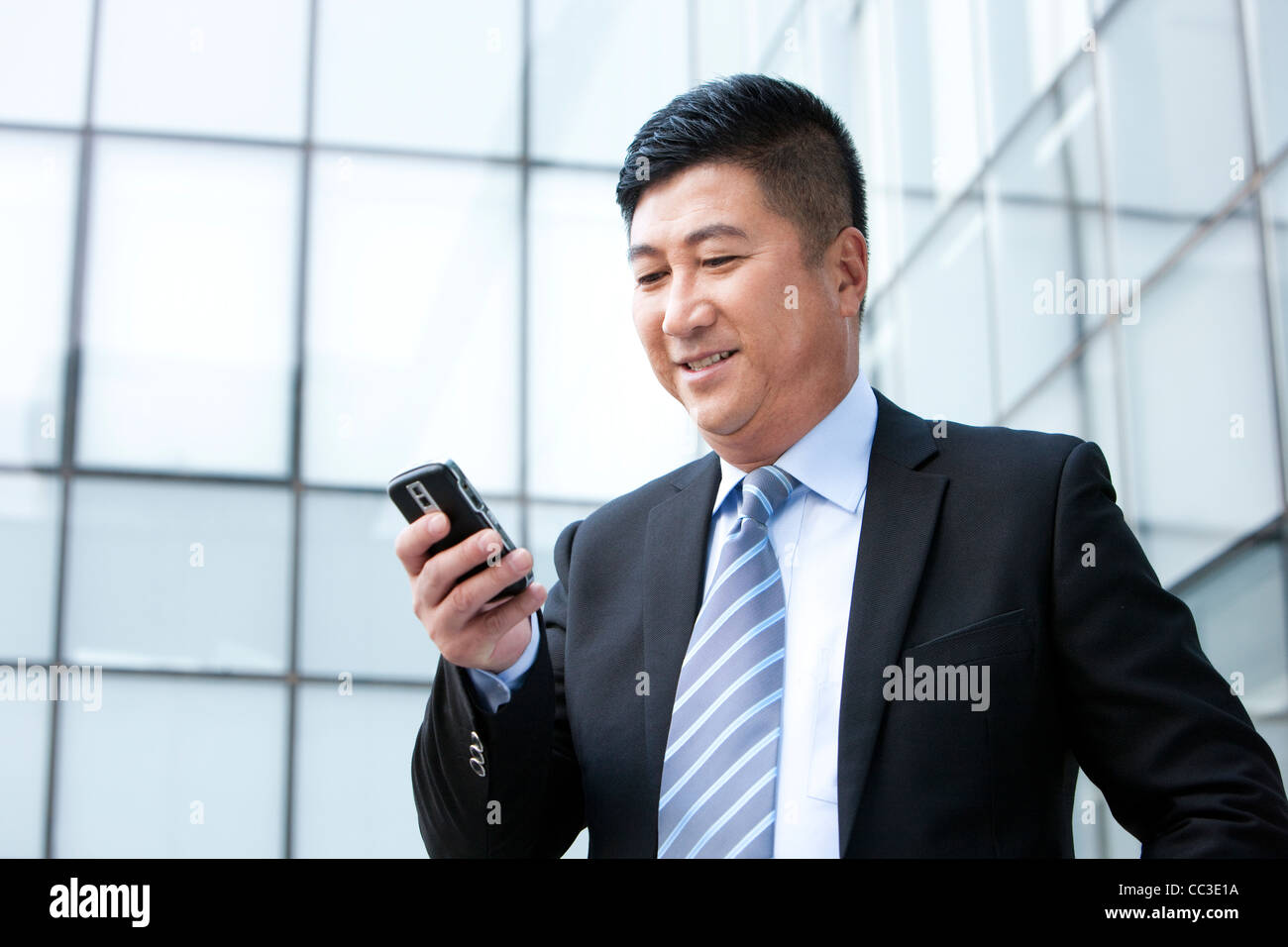 Businessman checking his phone Stock Photo - Alamy