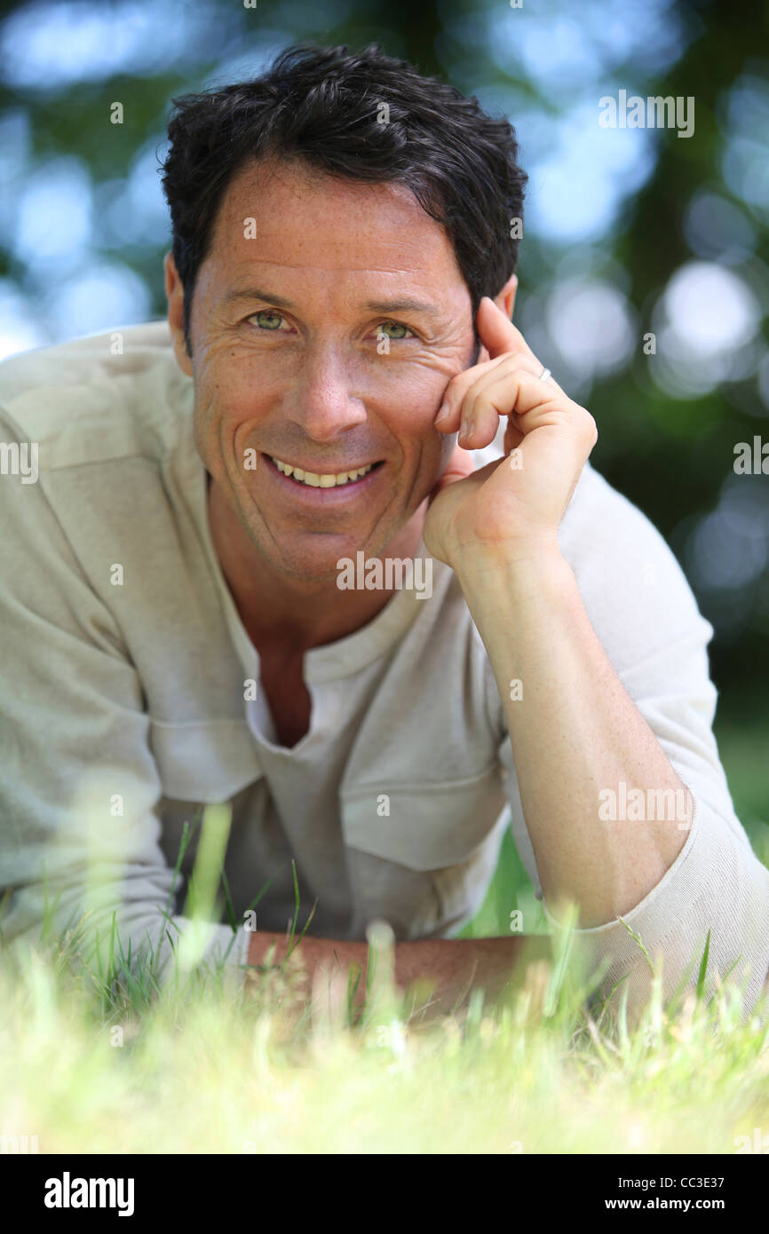 Man smiling lying on the grass Stock Photo - Alamy