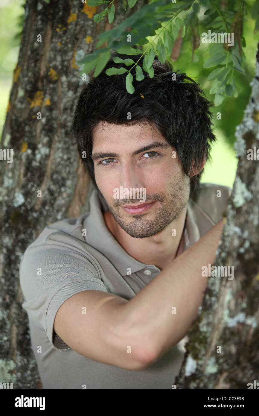 Man leaning against tree Stock Photo - Alamy