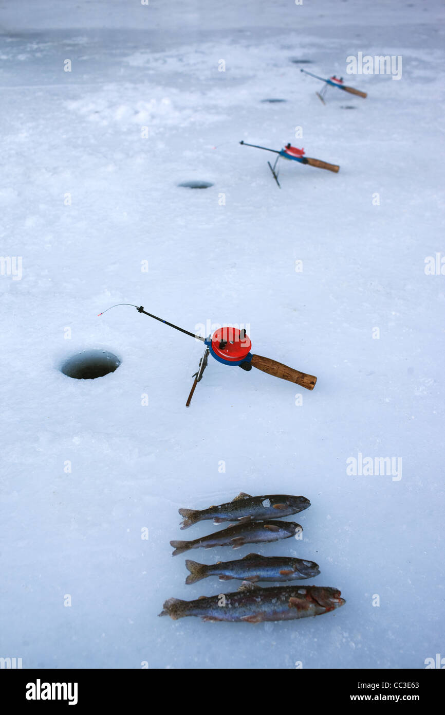 Little winter fishing rods in the hole and fish on ice Stock Photo - Alamy