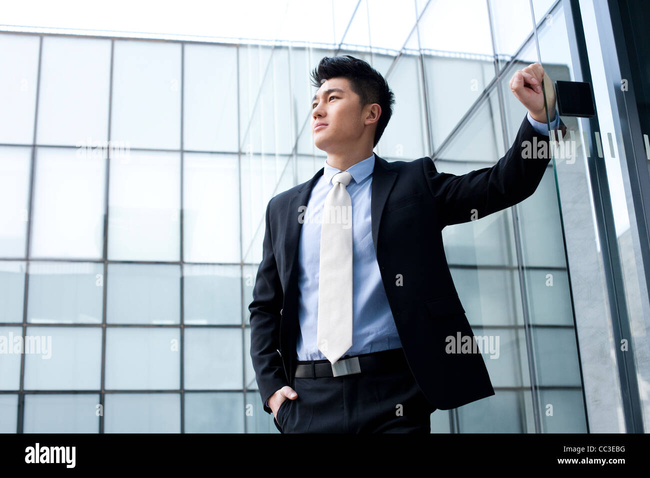 Businessman leaning on the wall Stock Photo - Alamy