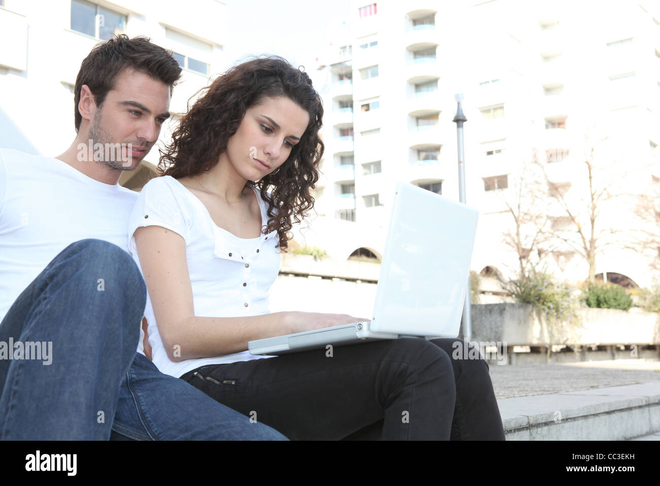 Couple using laptop computer outdoors Stock Photo - Alamy