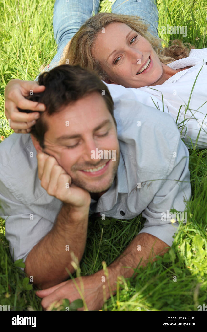 couple lazing on grass Stock Photo - Alamy