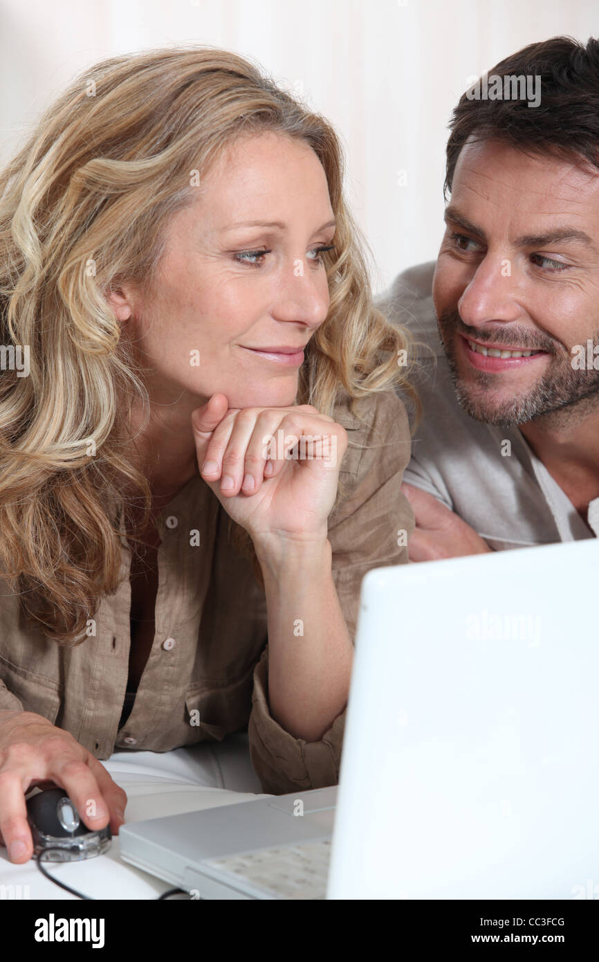 Couple sat by computer Stock Photo - Alamy