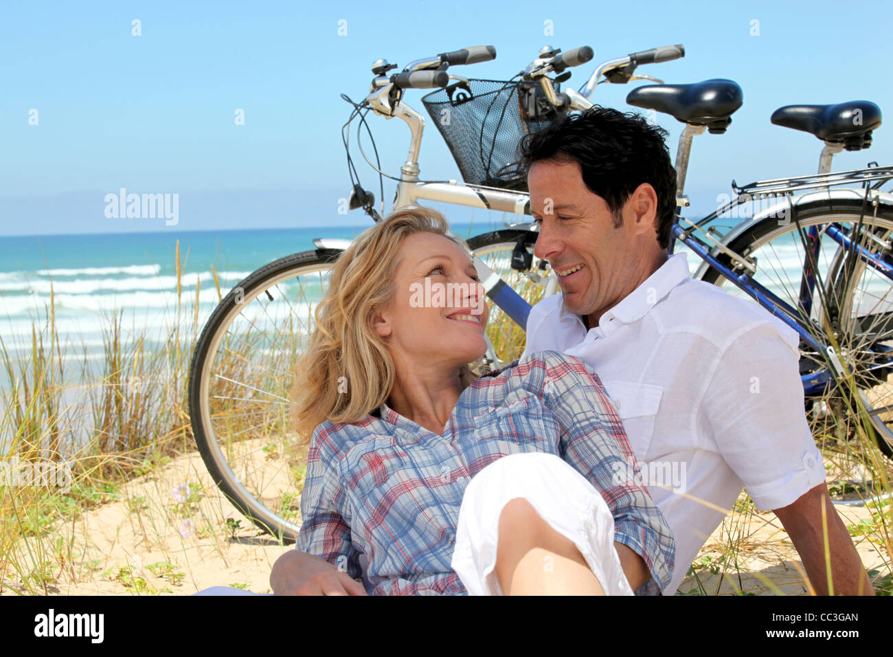 Couple resting by the sea Stock Photo - Alamy