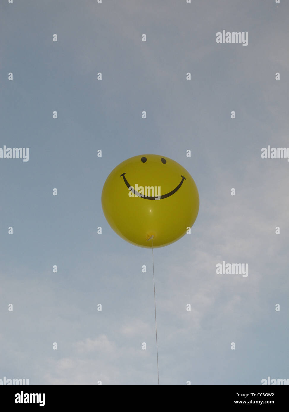 smiley face balloon flying in sky Stock Photo - Alamy