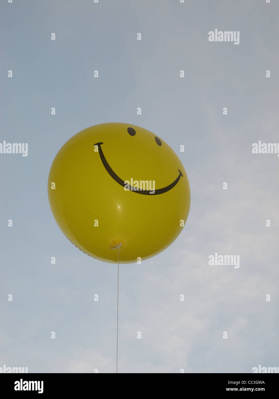 smiley face balloon flying in sky Stock Photo - Alamy